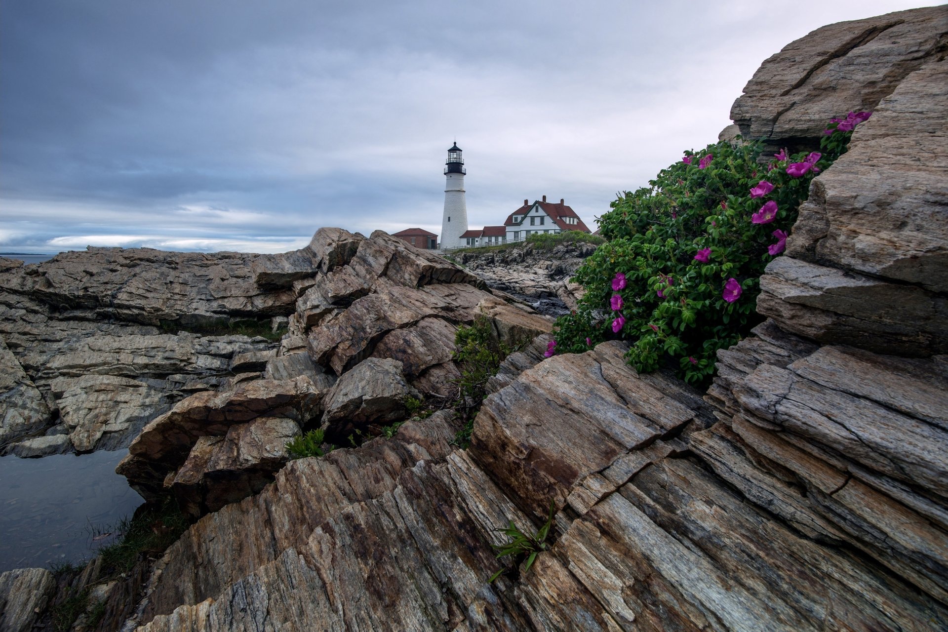 Majestic Lighthouse Amid Rugged Coastal Rocks – Stunning HD Wallpaper