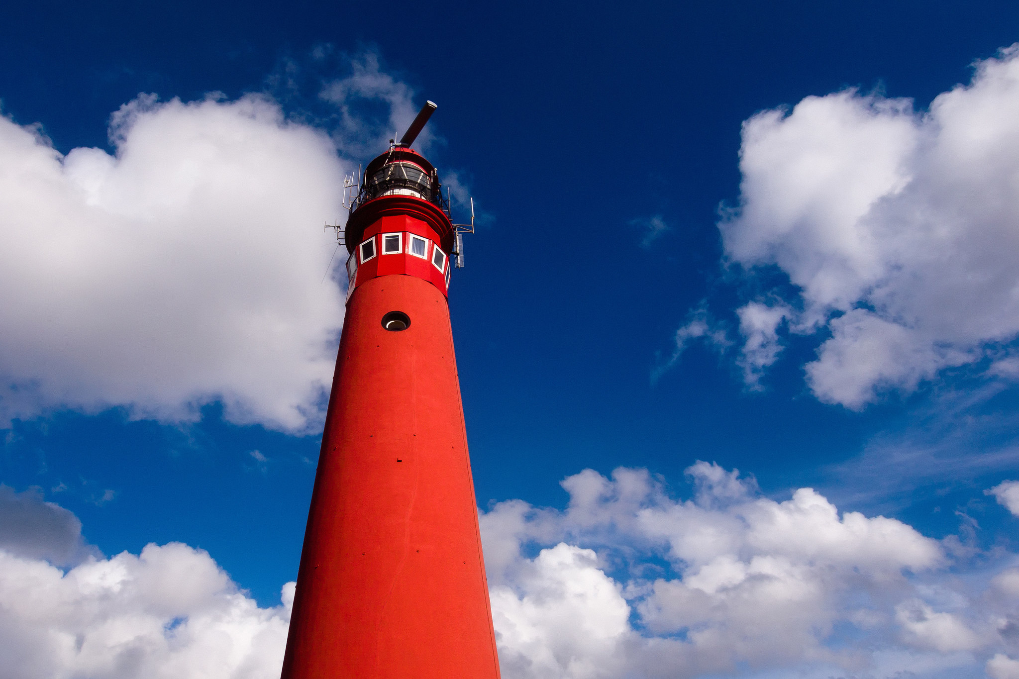 HD Wallpaper of a Striking Red Lighthouse Against a Blue Sky