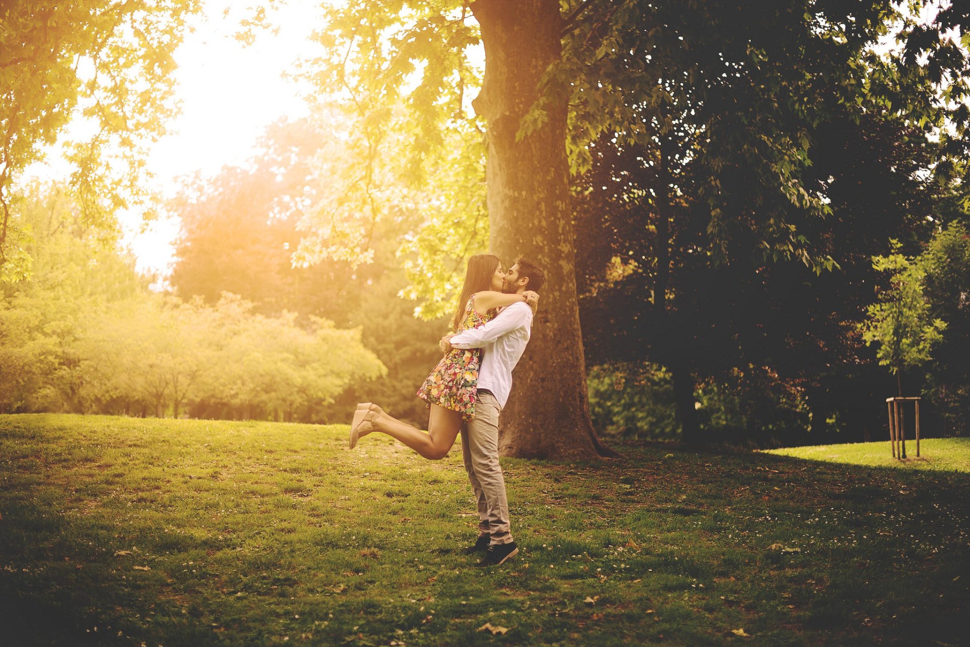 Sunlit Love: A Couple’s Joyful Moment in the Park – HD Romantic Wallpaper
